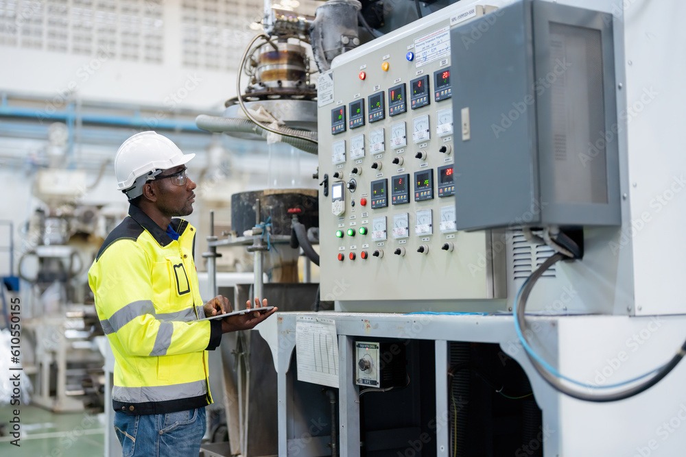 African male engineer technician manager Using a tablet to control tasks and looking at the ...