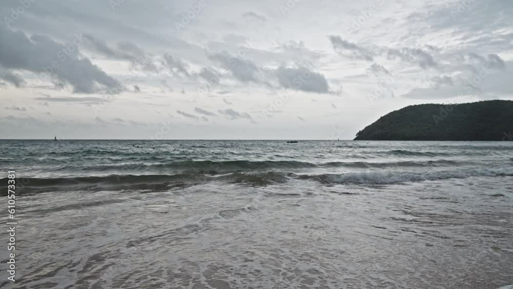 dramatic, desaturated waves crashing on a sandy beach under a ...