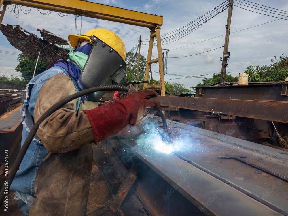 welder is welding a steel project with a welding process flux cored arc ...