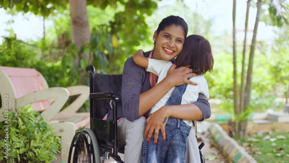 Excited girl kid hugging his mother with disability on wheelchair while ...