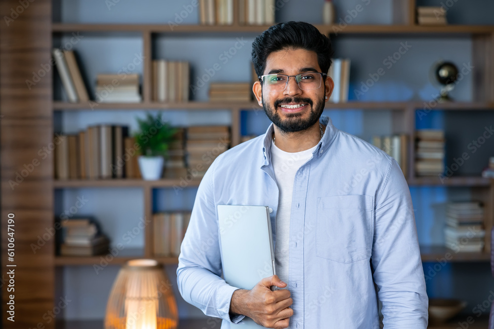 Foto de Smiling IT worker in blue shirt look at camera holding laptop ...