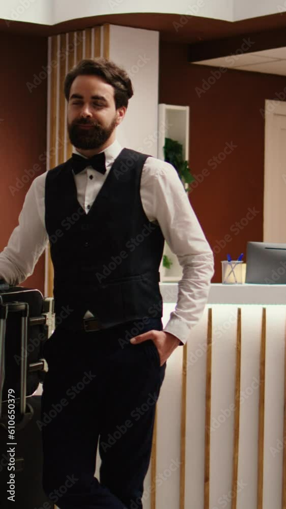 Vertical Video Panning shot of happy smiling professional bellhop ...