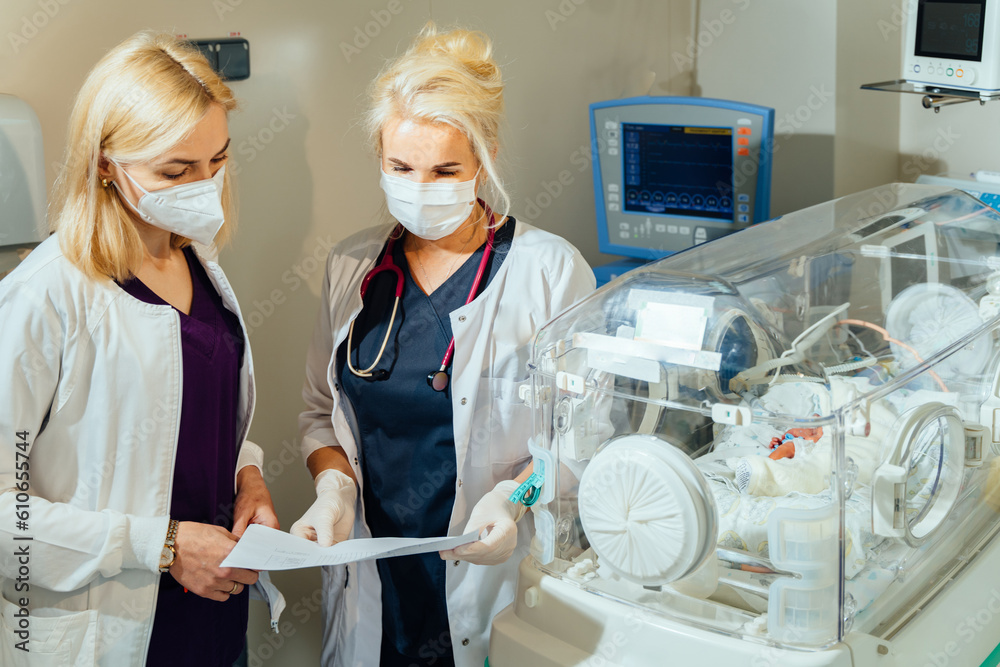 Neonatal Resuscitation. Doctor's team doing intensive therapy to look ...