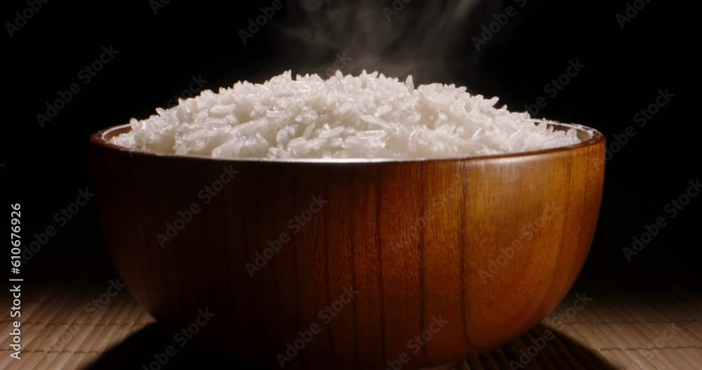 Hot white cooked rice steam bowl black background slow motion, Close up ...