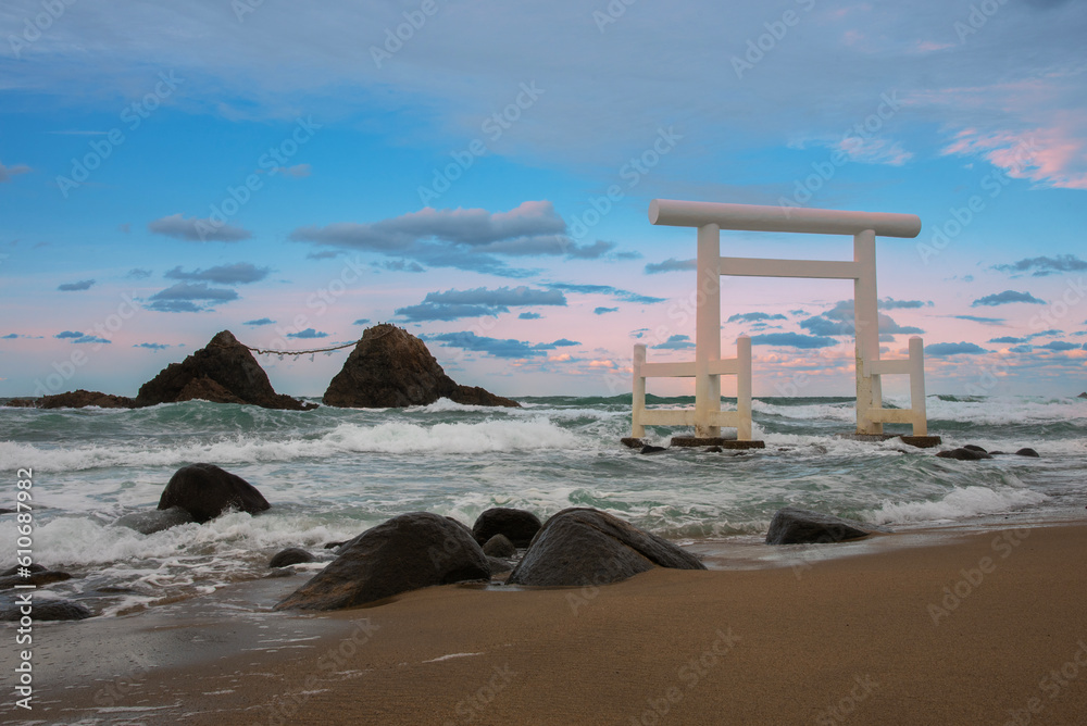 Poster The sun setting on the horizon of beach where a white Shinto ...