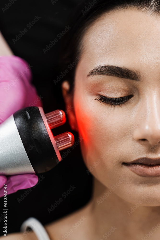 Radio frequency lifting with red light for young woman close-up ...