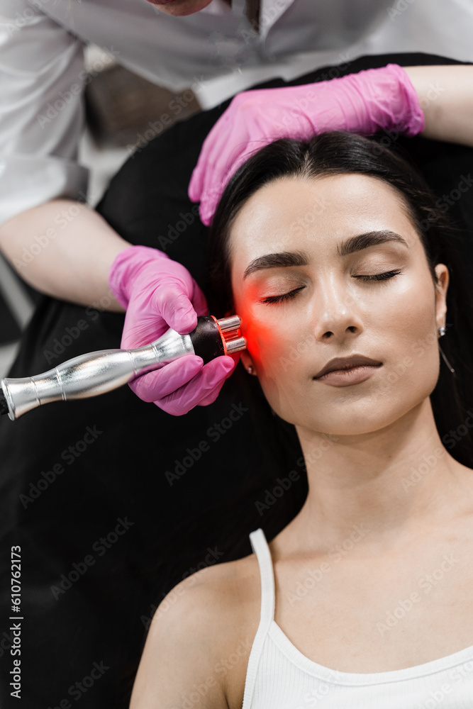 Radio frequency lifting with red light for young woman close-up ...