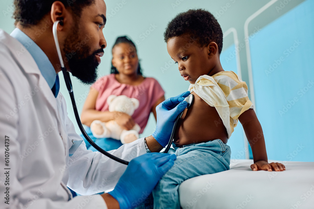 Small black kid being examined with stethoscope during medical checkup ...