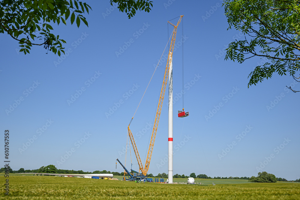 Installation of a wind turbine, high crane lifting the nacelle onto the ...
