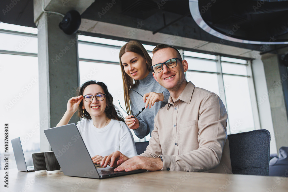 Meeting of office workers at the computer. Creative team sharing laptop ...