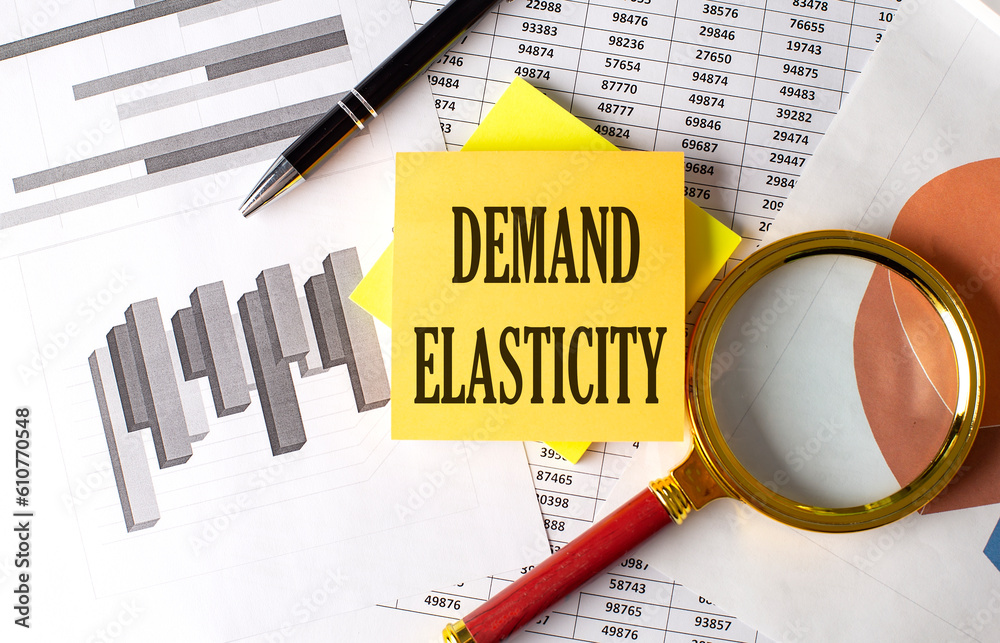 DEMAND ELASTICITY text on a sticky on the graph background with pen and ...