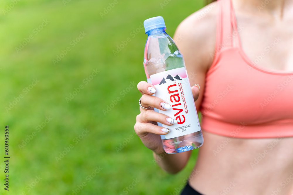 Illustrative editorial of famous bottled French Evian water in female hand. Evian is a French ...