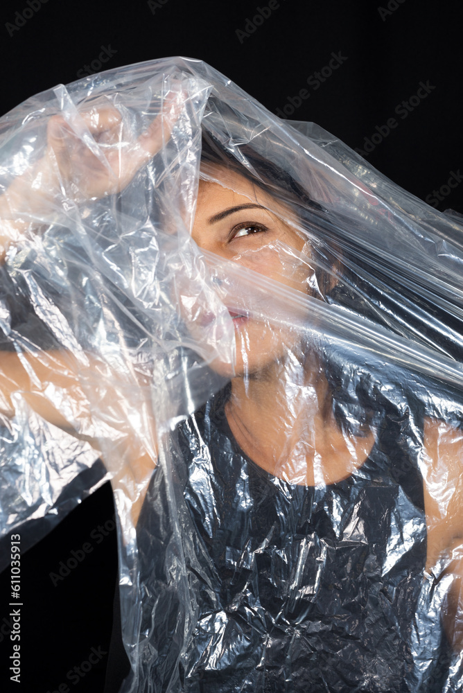 A woman with a plastic bag over her head looking through a hole ...