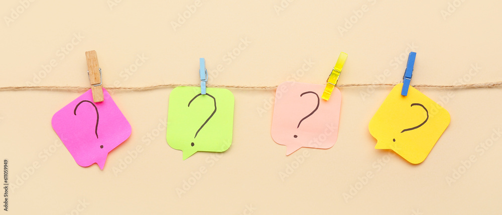 Paper sticks with question marks on rope against beige background Stock ...