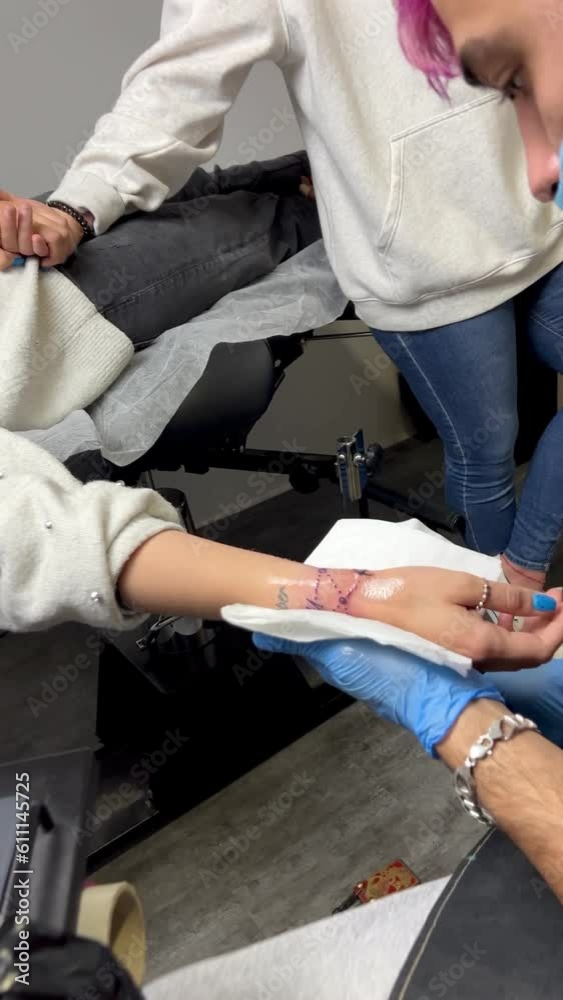 vertical 4k video of a tattoo artist cleaning and sterilizing a tattoo ...