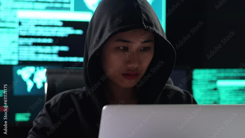 Close Up Of Asian Female Hacker In A Hood Works On A Laptop With Maps And Data On Display ...