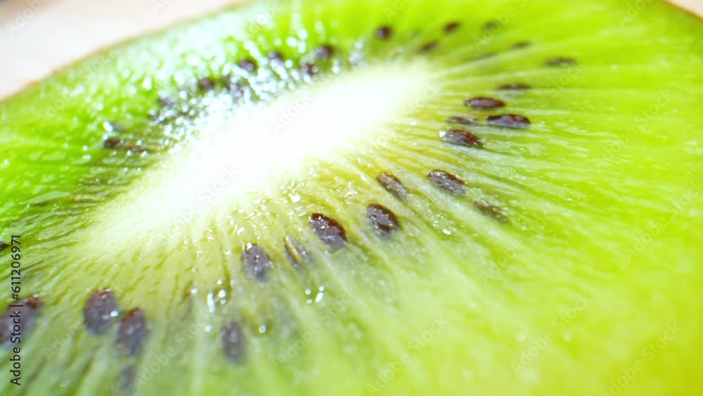 Macro video reveals the vibrant green flesh of a kiwi fruit, showcasing ...