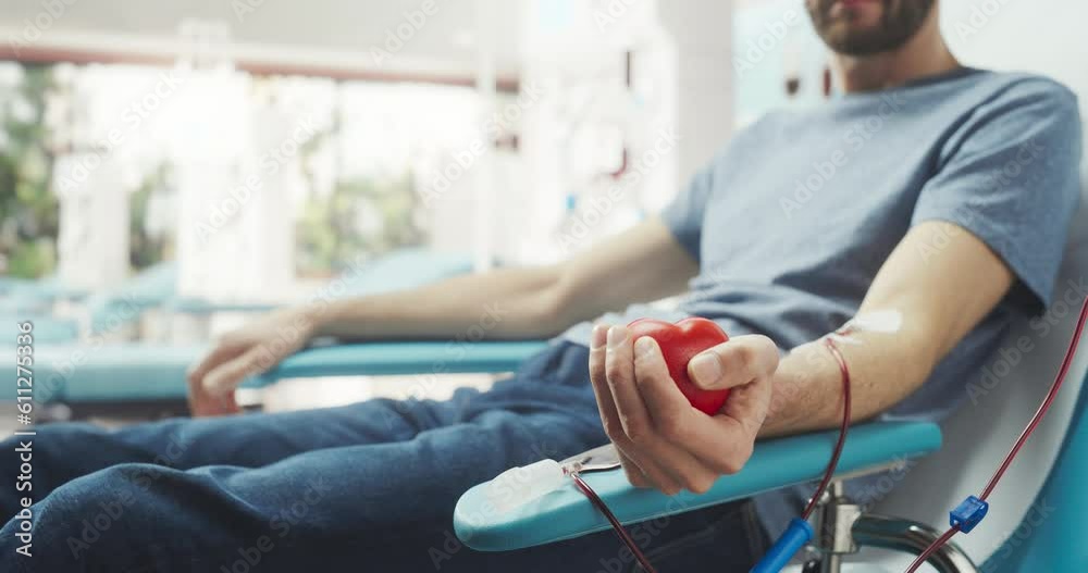 Close Up Shot Of Hand Of Male Blood Donor With an Attached Catheter ...