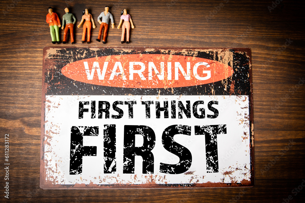 First things first. Warning sign with text on wood texture background ...