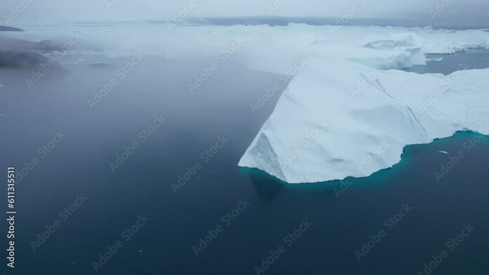 Elevated view flying between the iceberg peaks and large icebergs ...