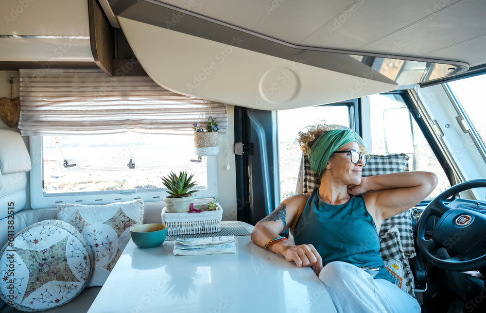 One young traveler woman enjoy time and relax inside modern camper van ...