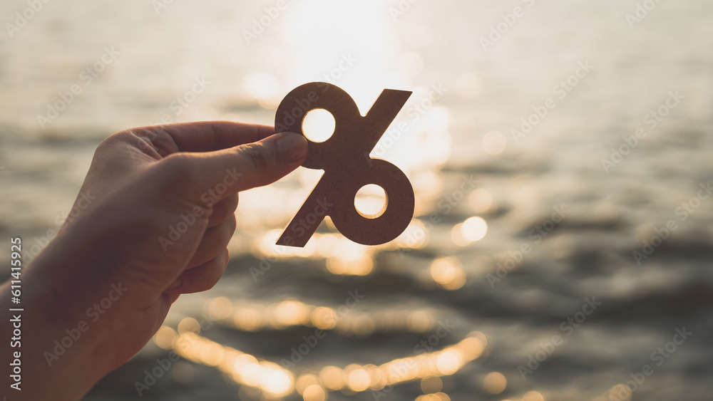 Businessman's hand holding a symbol Percentage with blur sea background ...
