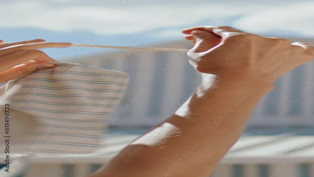 Woman hands taking swimsuit off rope closeup vertically. Bikini bra air ...