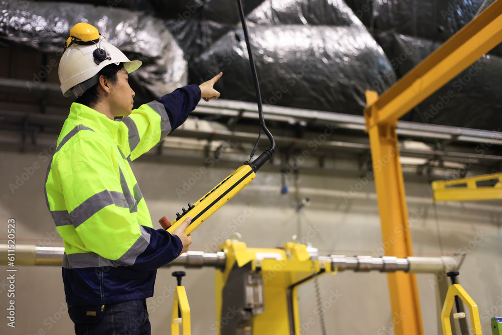 Young mechanical engineer with green safety jacket and white hardhat ...