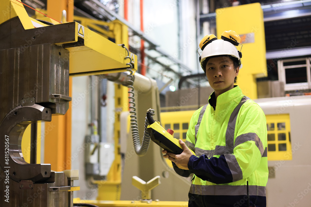 Young mechanical engineer with green safety jacket and white hardhat ...
