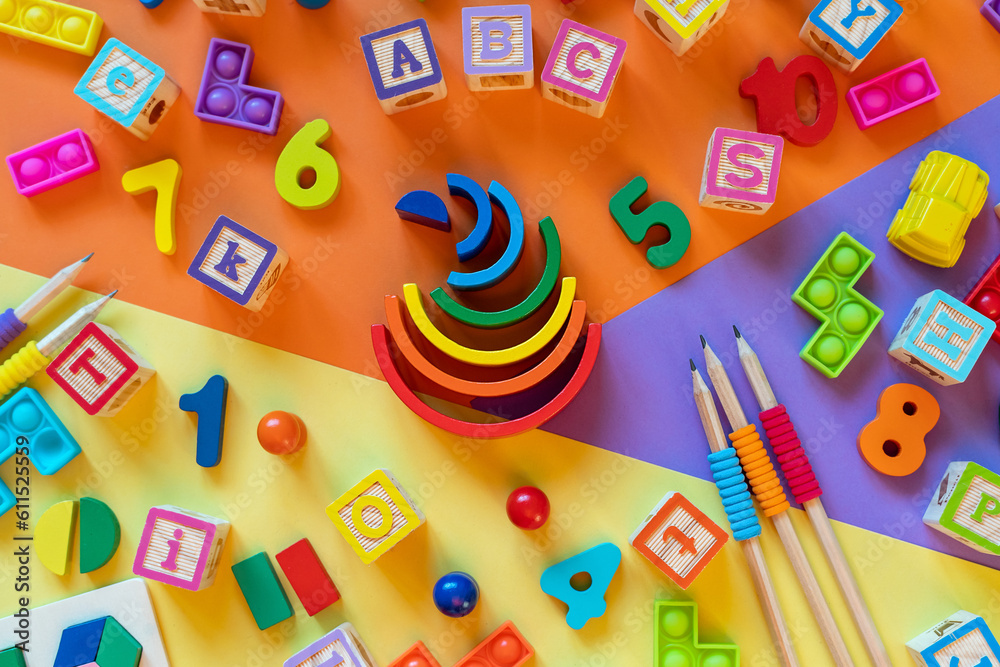 Wooden kids toys on colourful paper. Educational toys blocks, pencils ...
