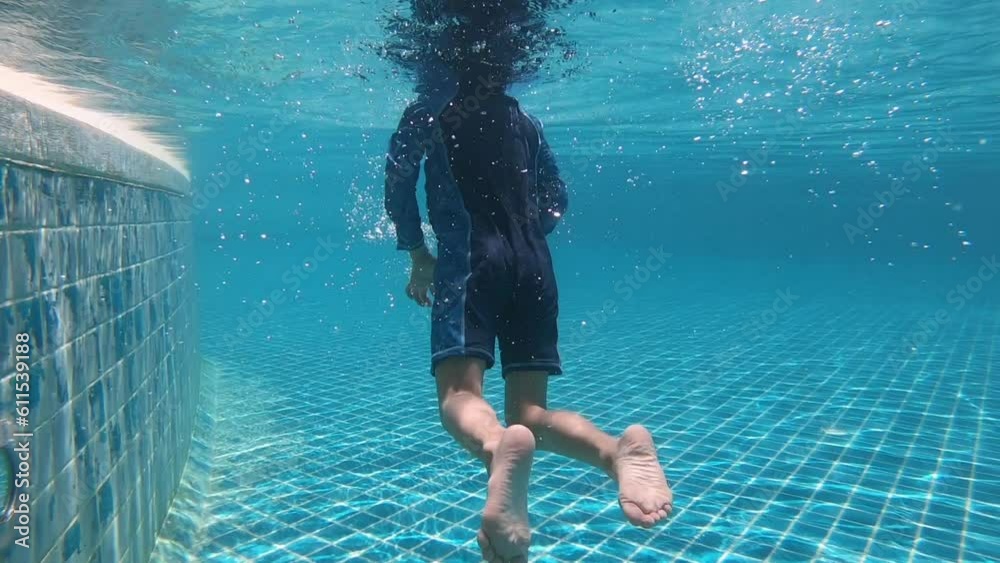a boy enjoying summer vacation, underwater view of happy child diving ...