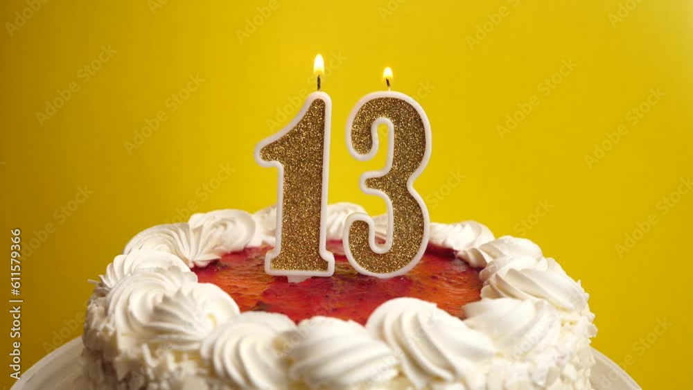 A candle in the form of the number 13, inserted into the holiday cake ...