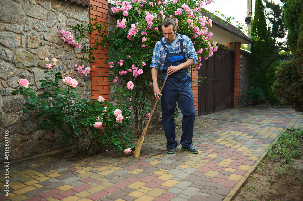 Foto de Full length portrait of a male gardener in blue gardening ...
