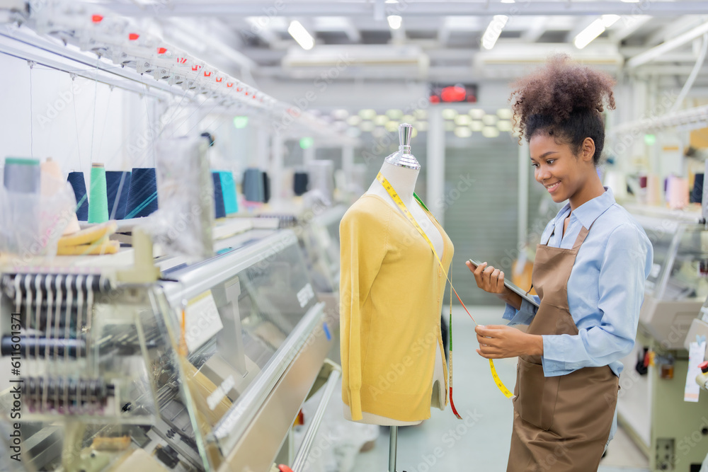American female designer, weaver Holding a design tablet and looking at ...