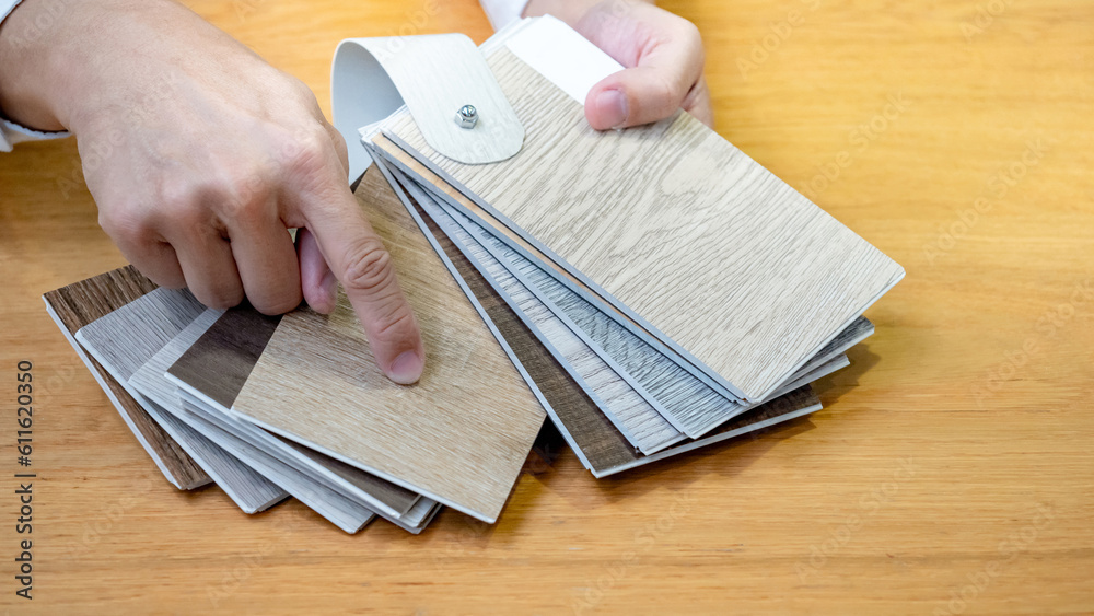 Designer hand choosing and pointing at wood texture laminate material ...