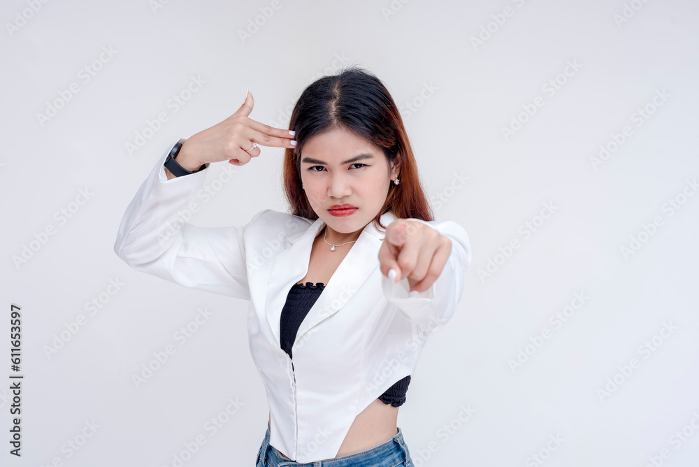An angry young woman pointing a finger gun to her head while pointing ...