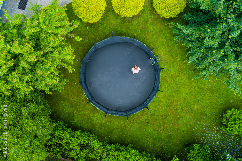Poster Aerial top-down view of a teenage girl jumping on a trampoline ...