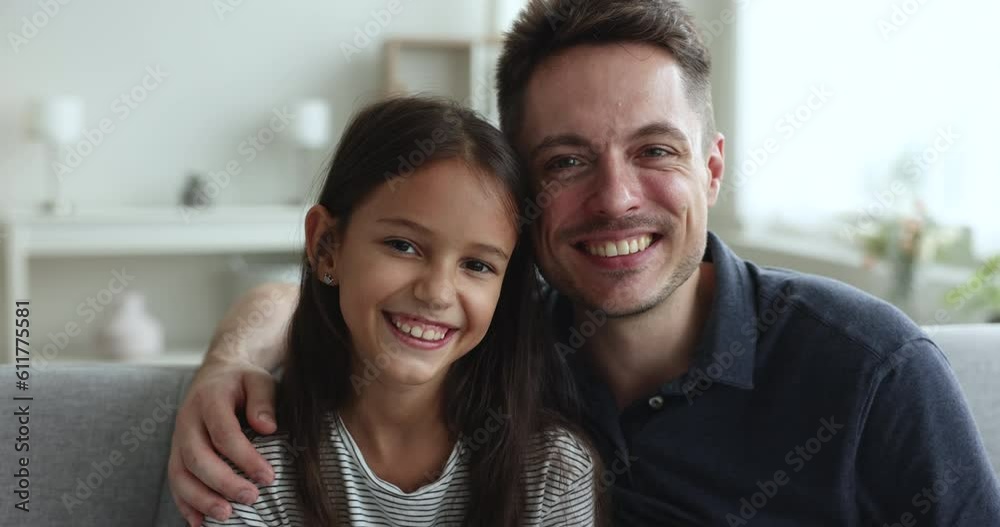 Close up smiling young father hugging his pretty daughter look at ...