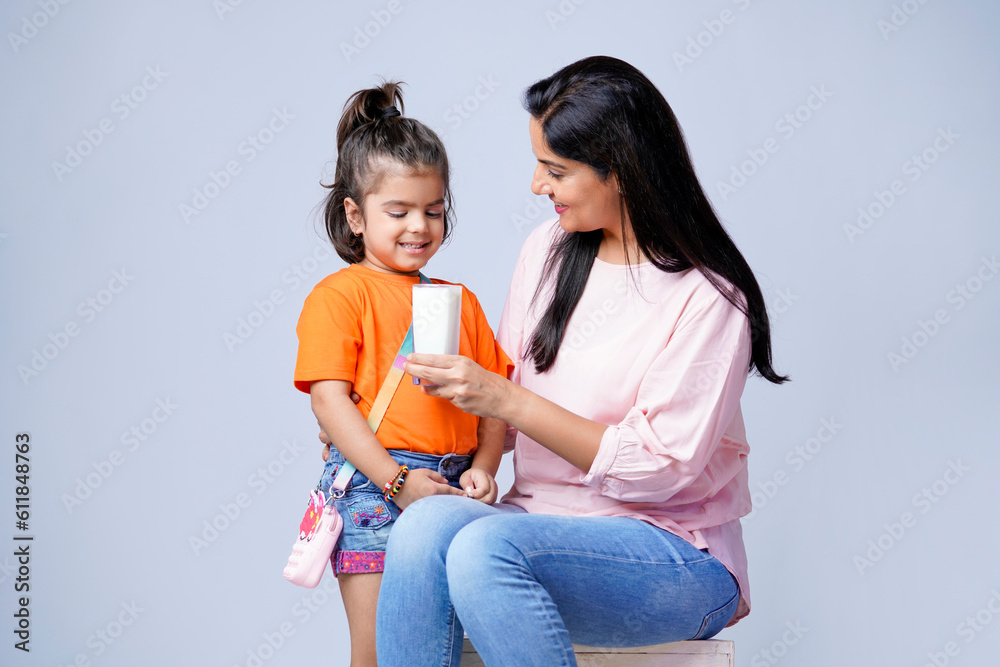 Indian mother giving milk in glass his daughter on white background. Stock Photo | Adobe Stock