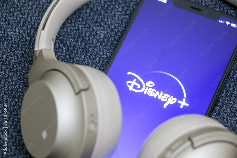 Watching Disney Plus on smartphone, Disney + logo on screen, gold ...