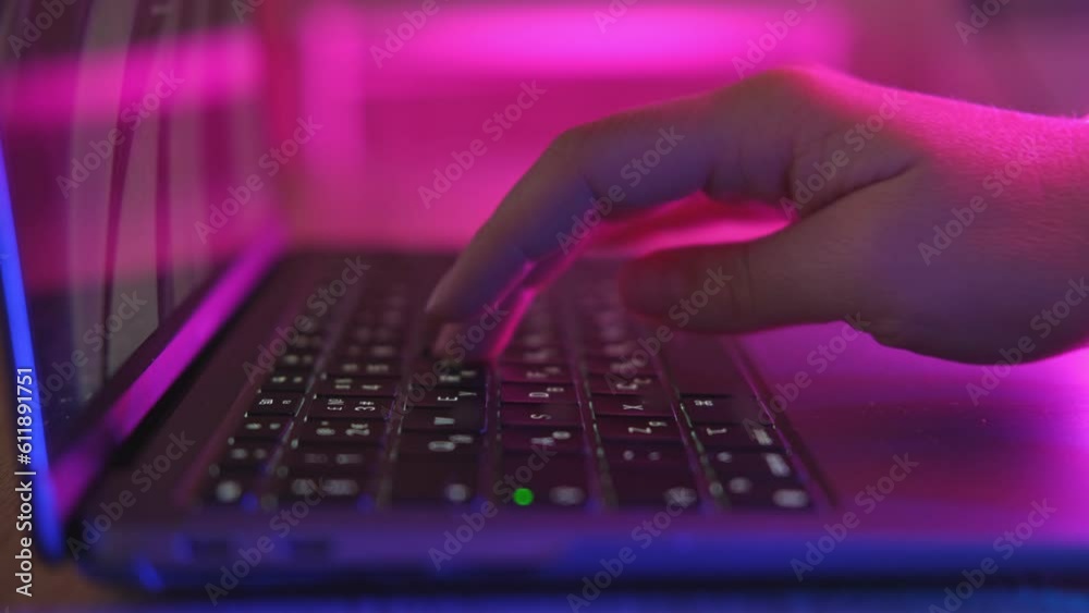 Person typing at laptop computer at night. Female uses keyboard, shakes ...