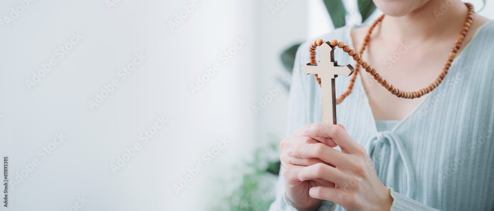 Yong woman holding cross or crucifix and praying or blessings from god ...