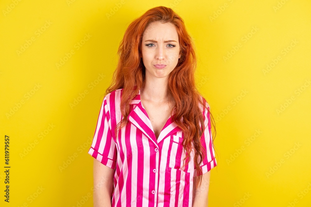 Dismal gloomy rejected Young red haired woman wearing pink pyjama over ...