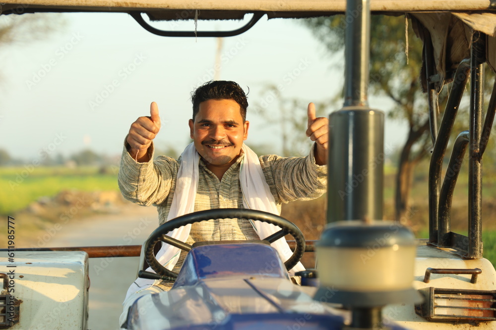 Happy Indian villager farmer sitting on the tractor enjoying the ...