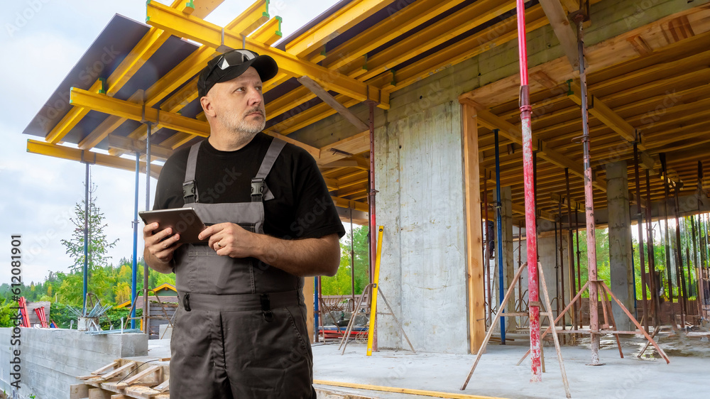Foto de Man builder. Foreman with tablet. Guy near house under ...