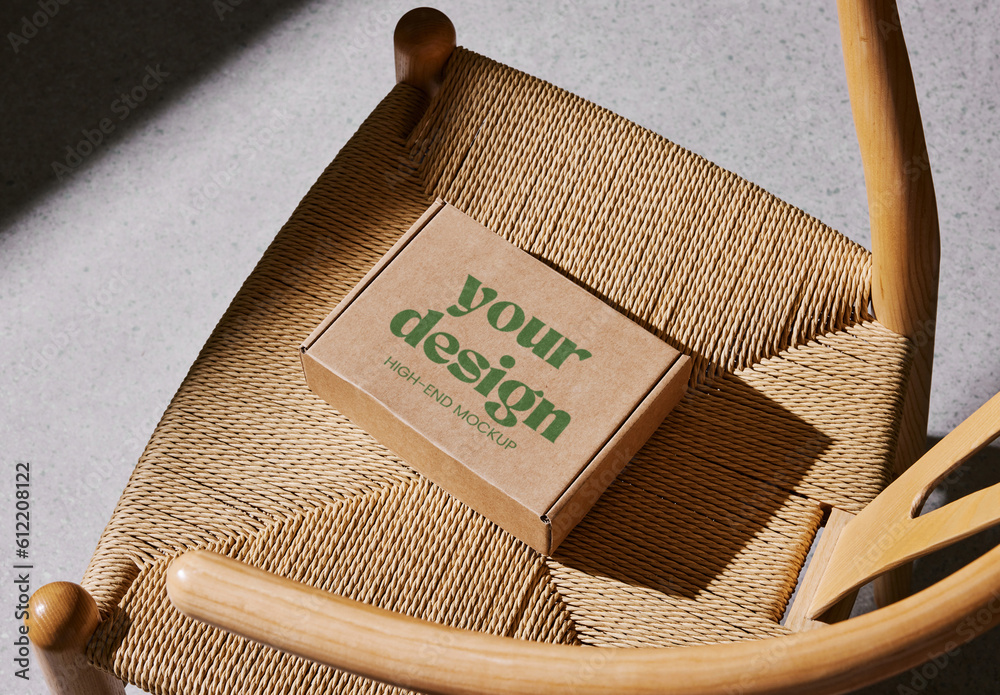 Mockup of customizable closed small rectangular cardboard box on chair ...