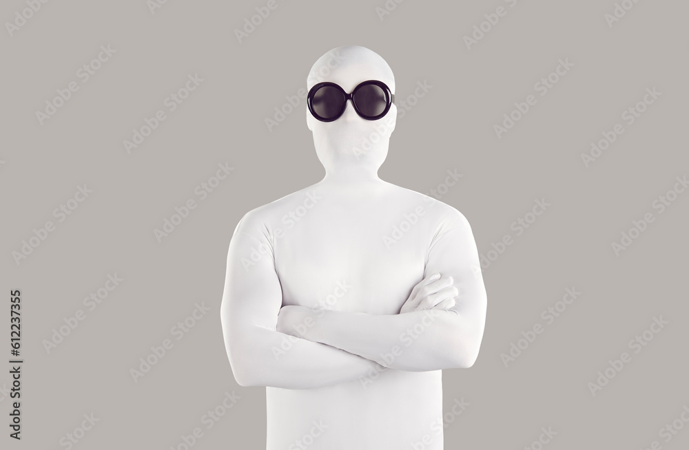 Portrait of person in bodysuit disguise and sunglasses. Man with secret ...