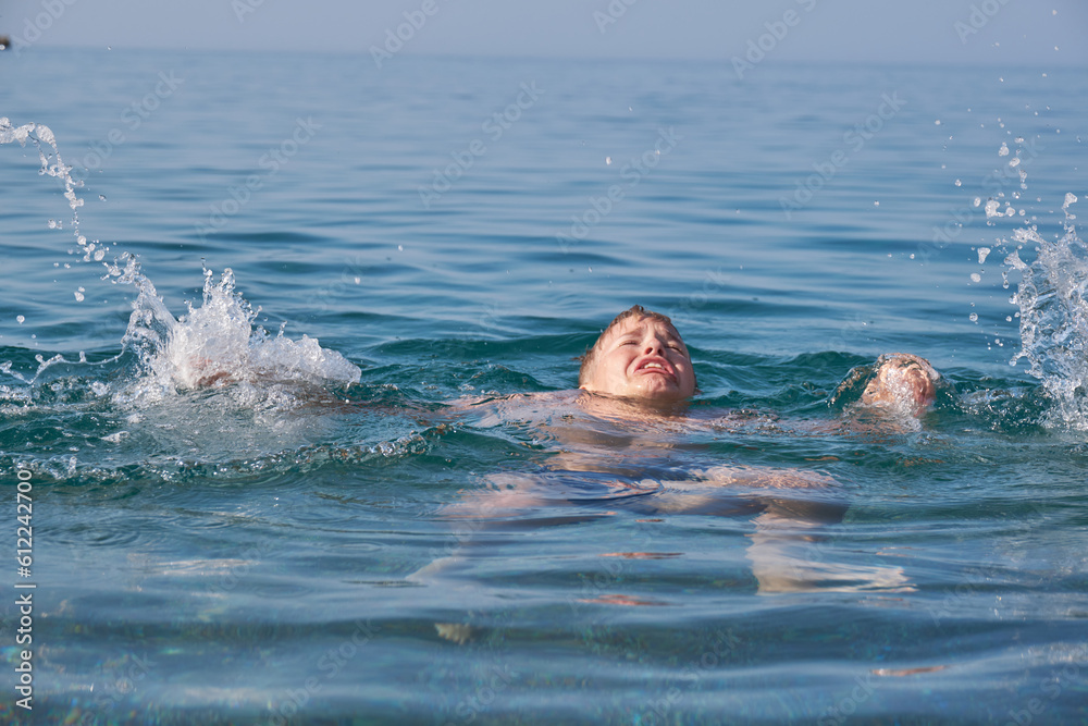The child is drowning in the sea, screaming and waving his arms. Stock ...