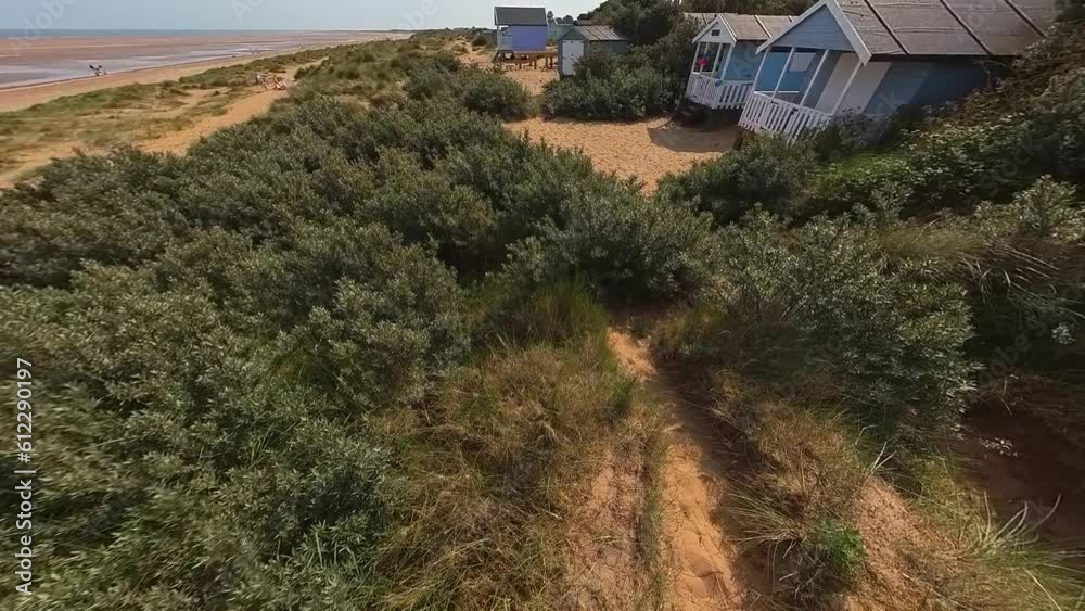 Tilt and reveal shot of traditional wooden beach huts and surf shacks ...