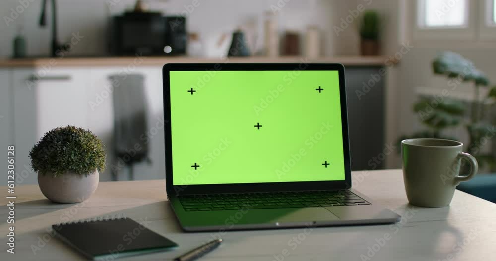 Laptop computer with green screen in bright kitchen. Chromakey layout ...
